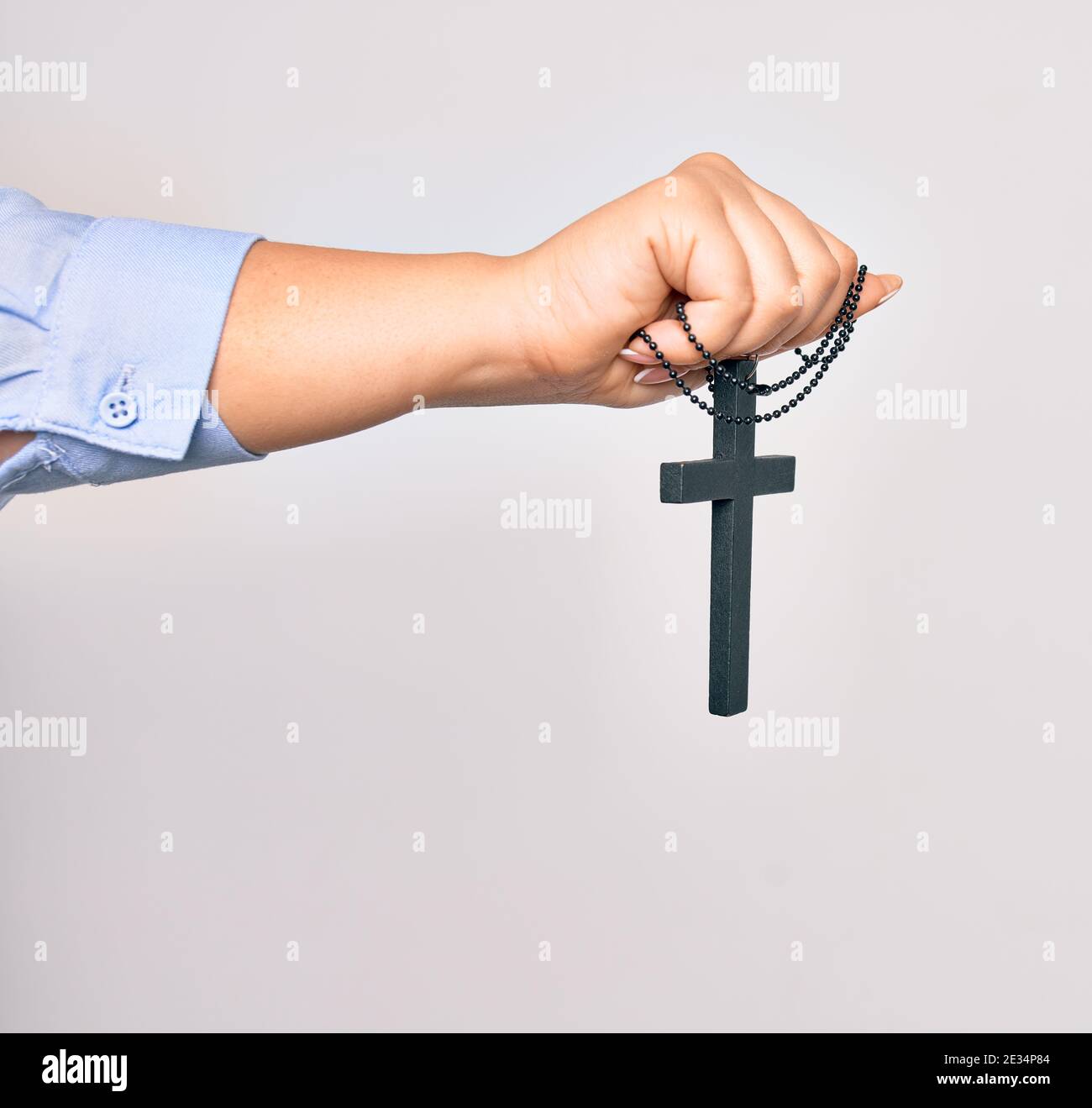 Hand of caucasian young catholic woman holding christian cross over ...