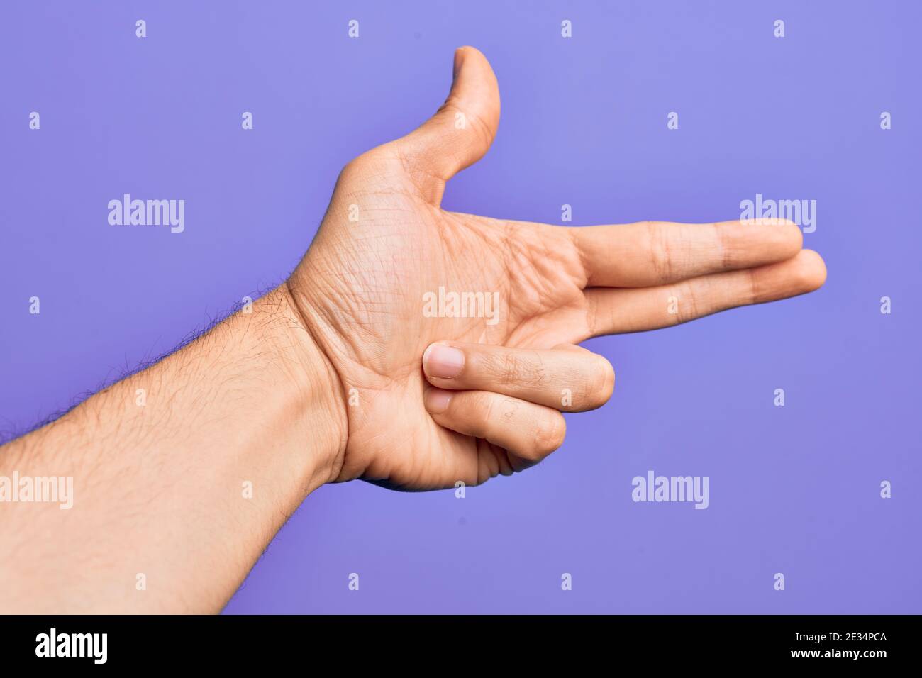 Hand of caucasian young man showing fingers over isolated purple ...