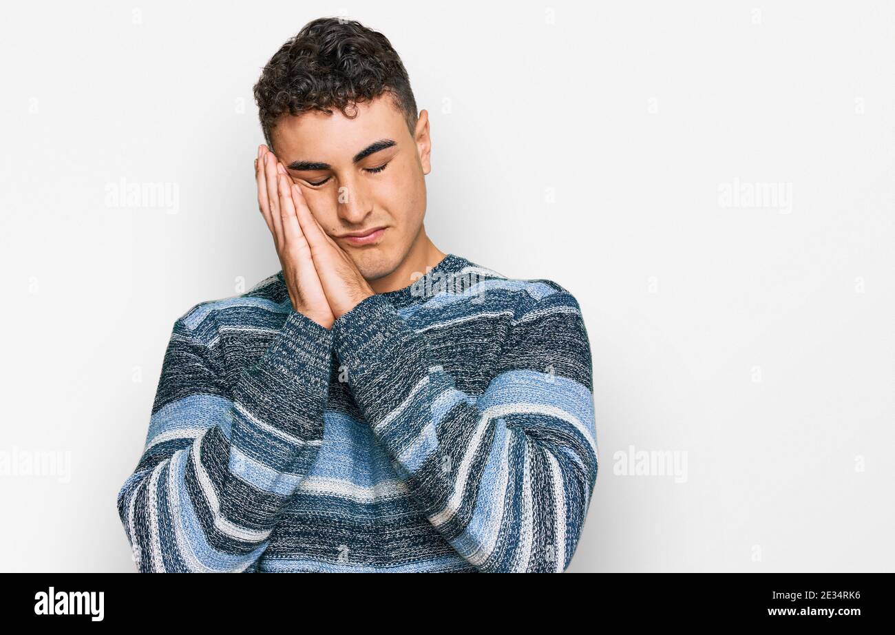 Hispanic young man wearing casual clothes sleeping tired dreaming and ...