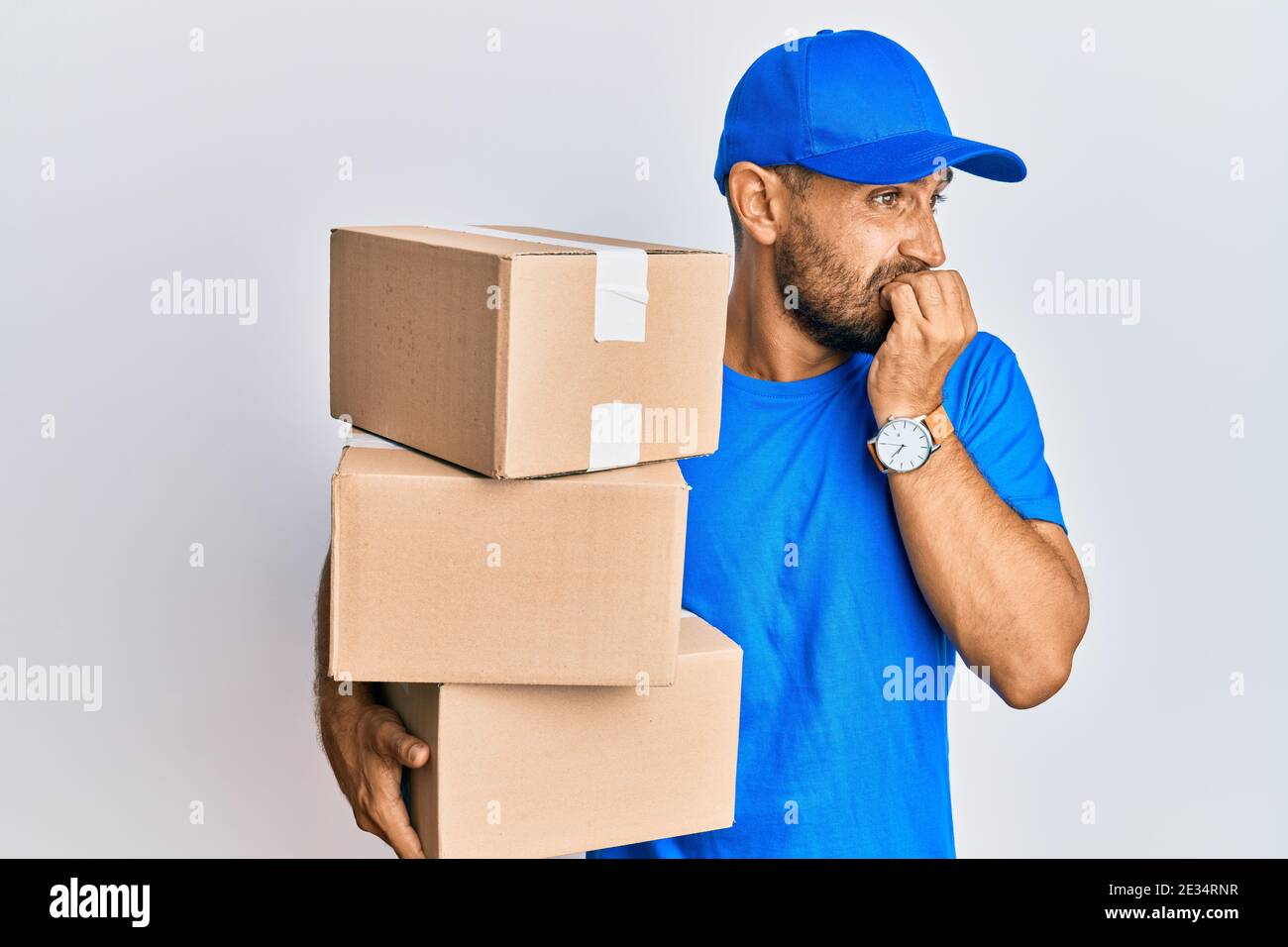 Handsome man with beard wearing courier uniform holding delivery ...
