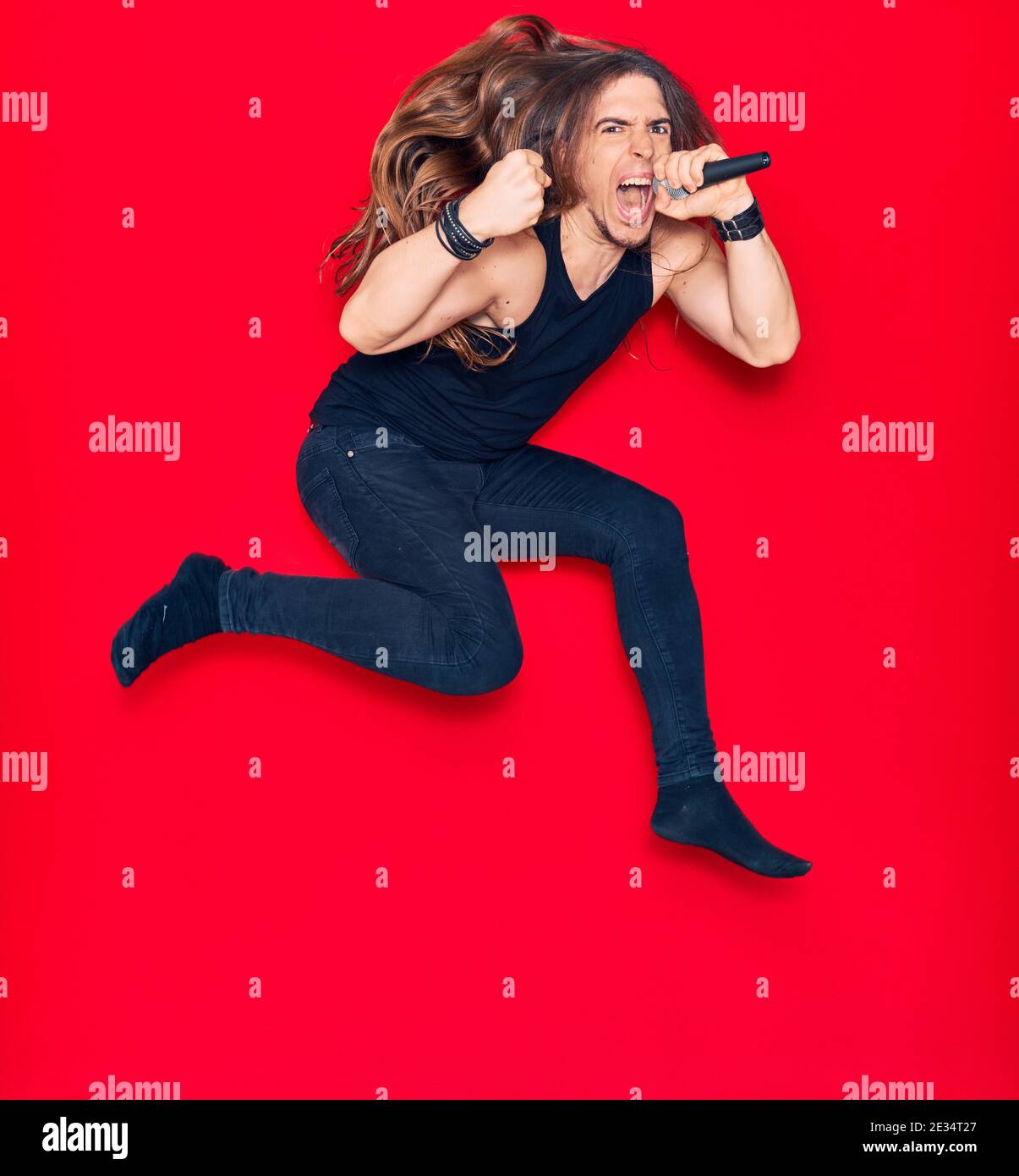 Young handsome heavy metal singer man with long hair and aggressive ...