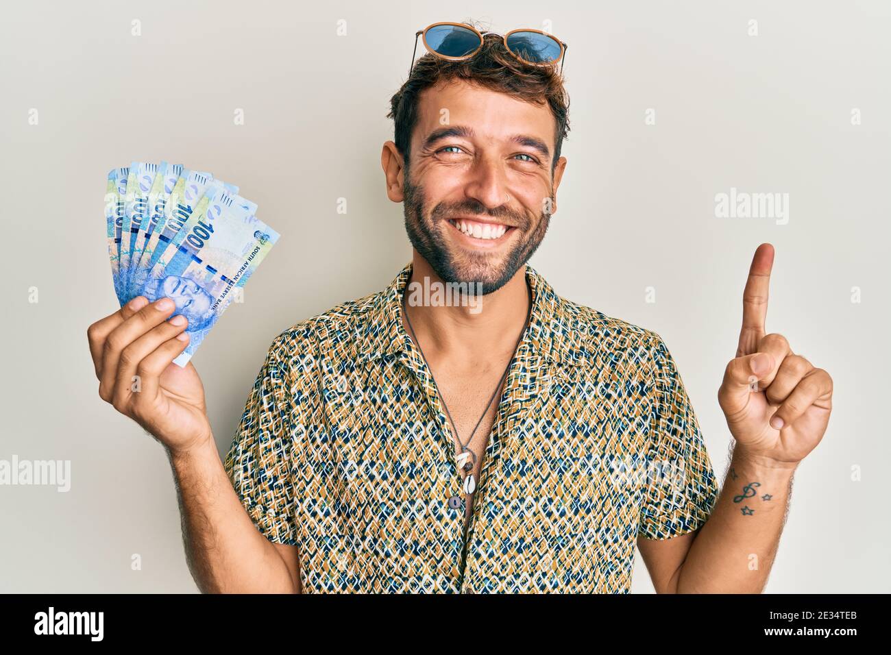 Handsome man with beard holding south african 100 rand banknotes ...