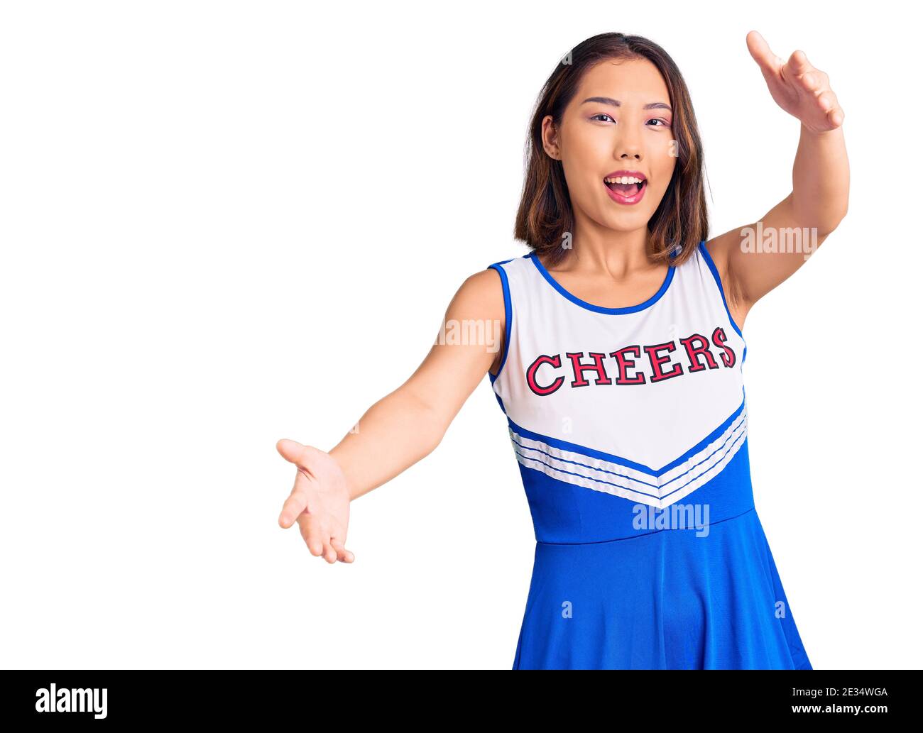 Young beautiful chinese girl wearing cheerleader uniform looking at the ...