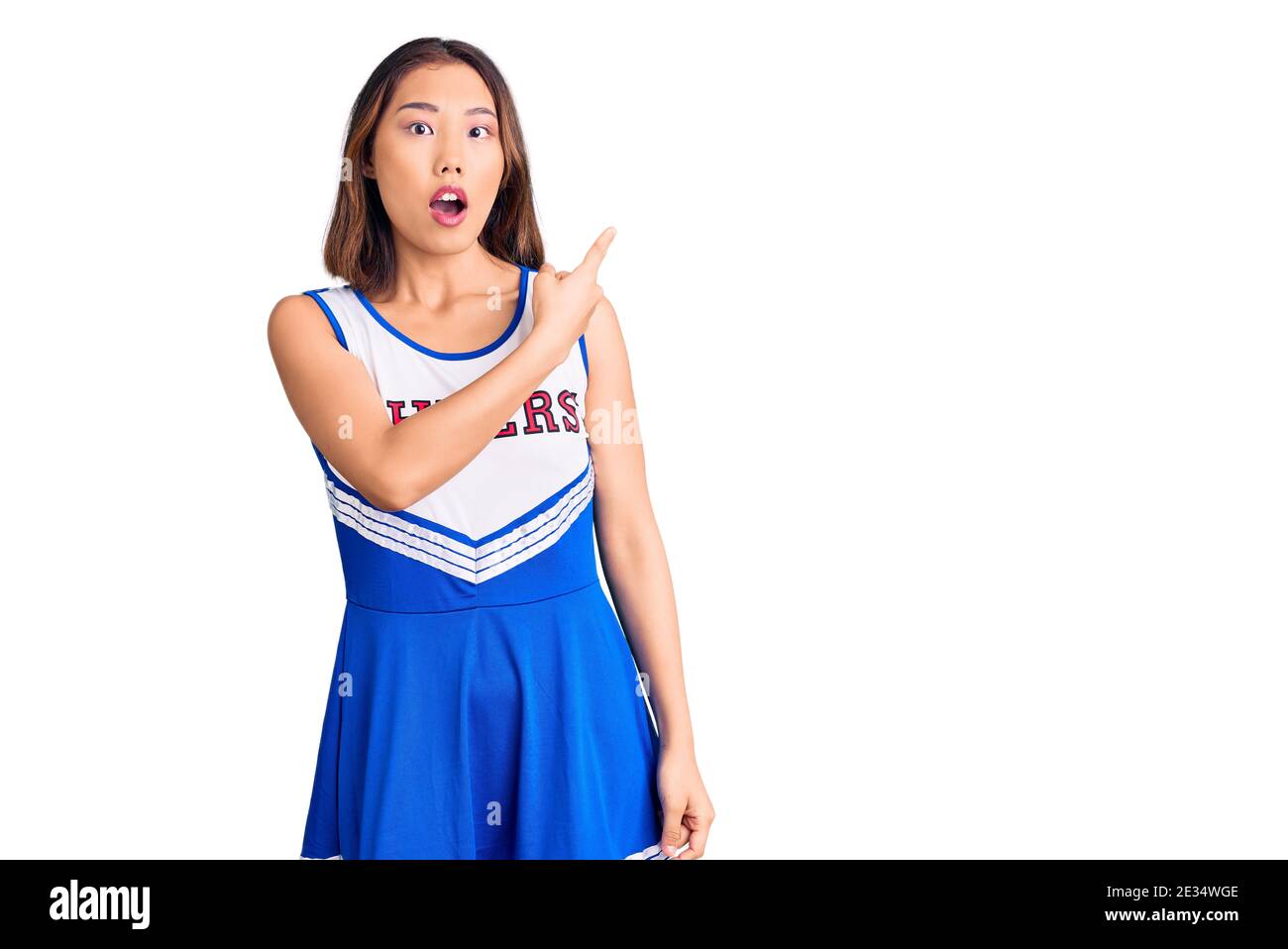 Young beautiful chinese girl wearing cheerleader uniform surprised ...