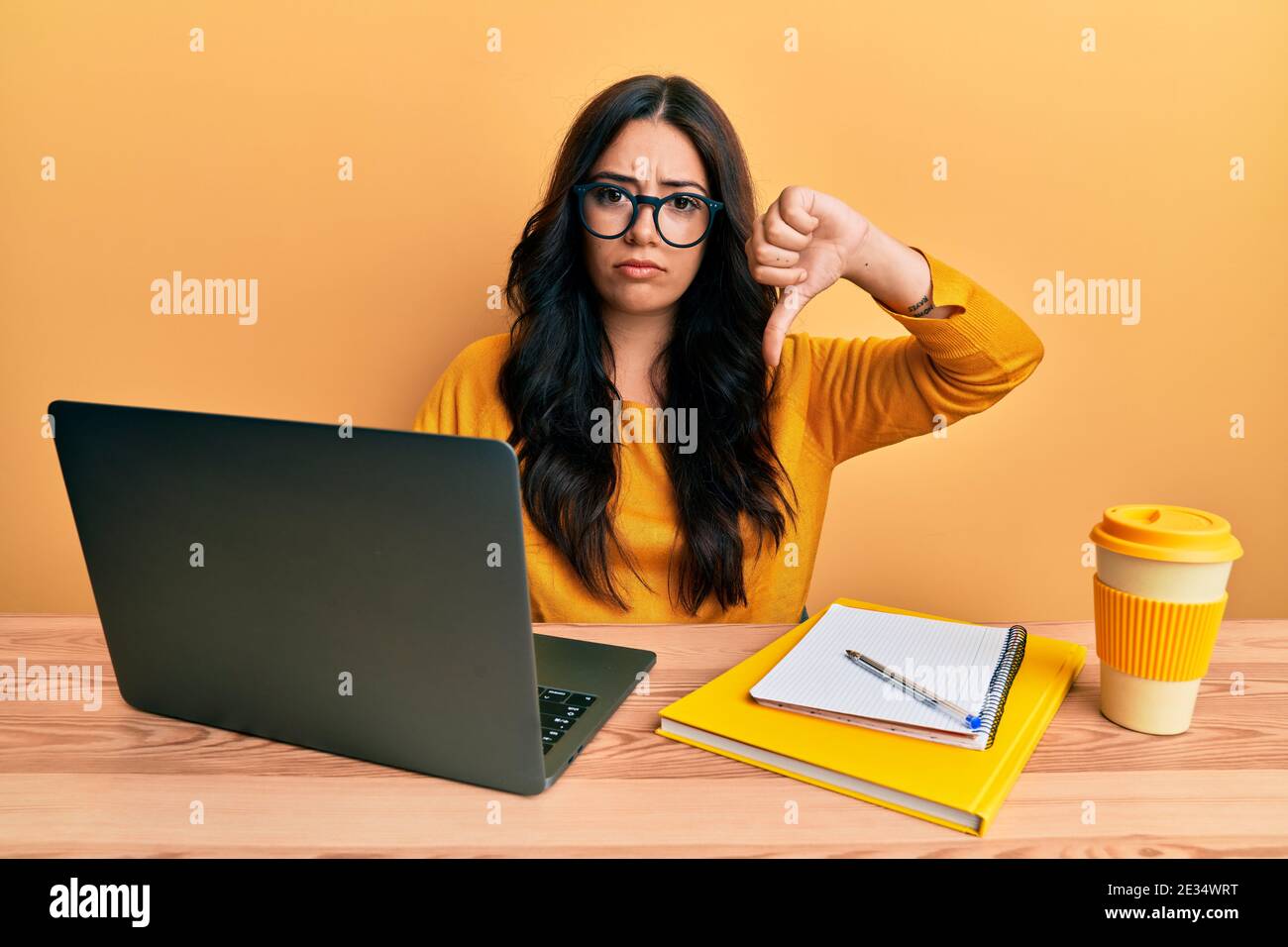 Beautiful brunette young woman working at the office wearing glasses ...