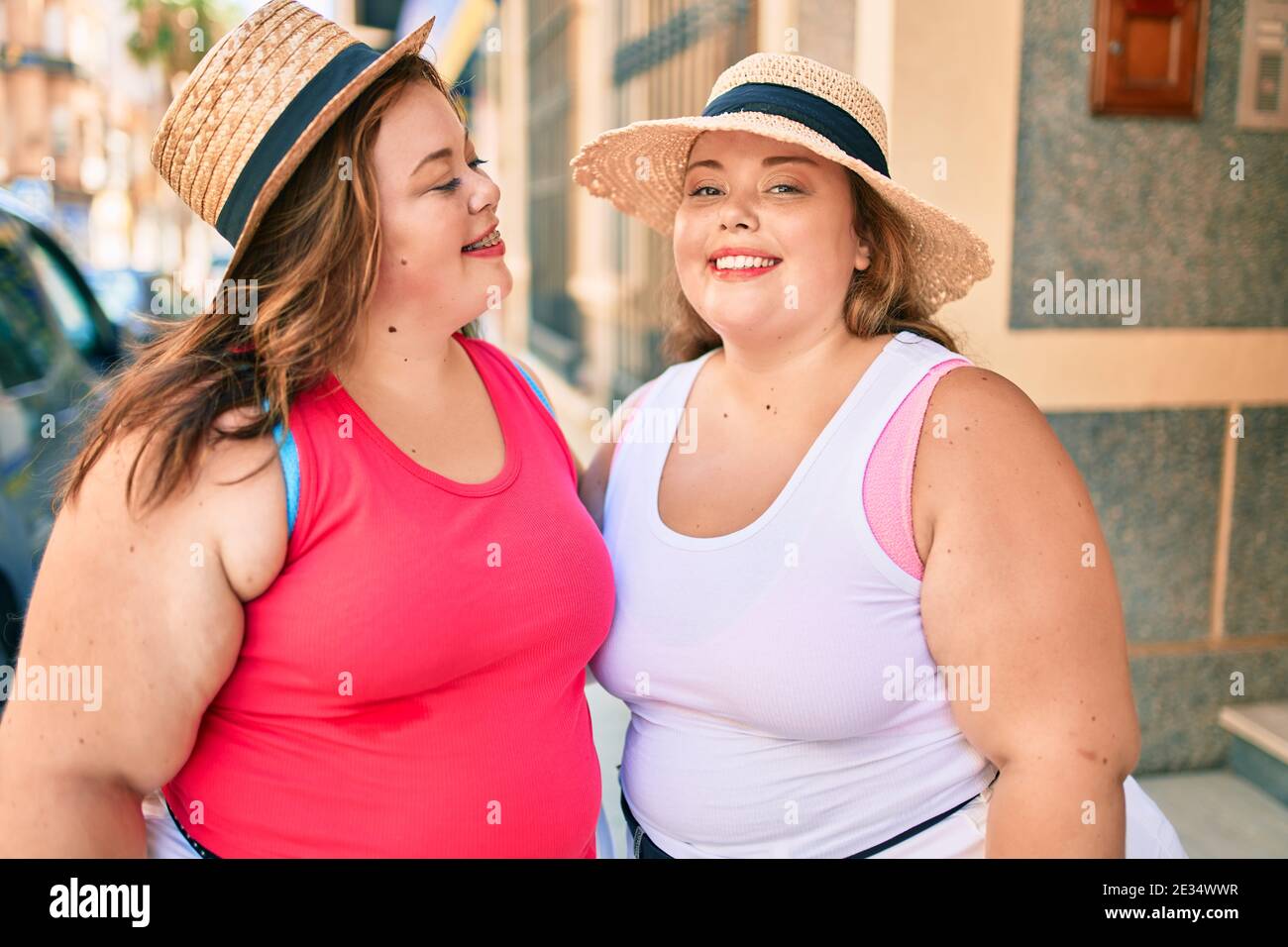Two plus size overweight sisters twins women hugging together outdoors ...