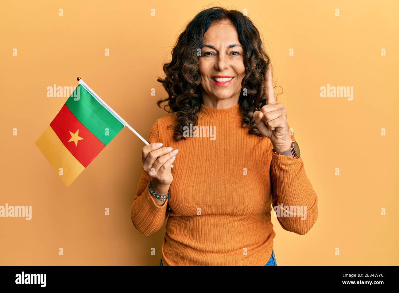 Middle age hispanic woman holding cameroon flag smiling with an idea or ...