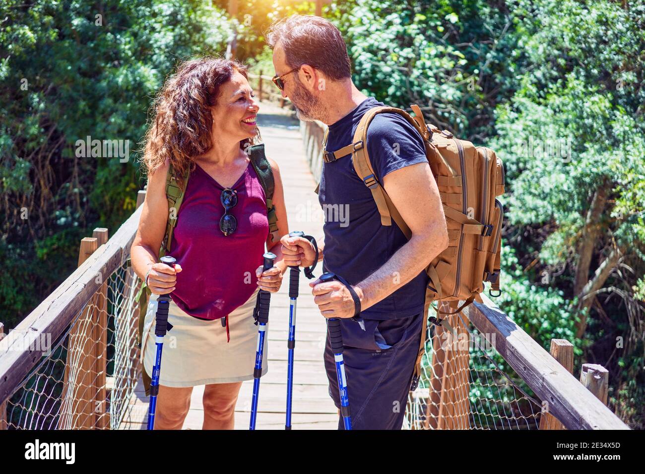 Beautiful couple of hiker wearing explorer clothes and backpack smiling ...