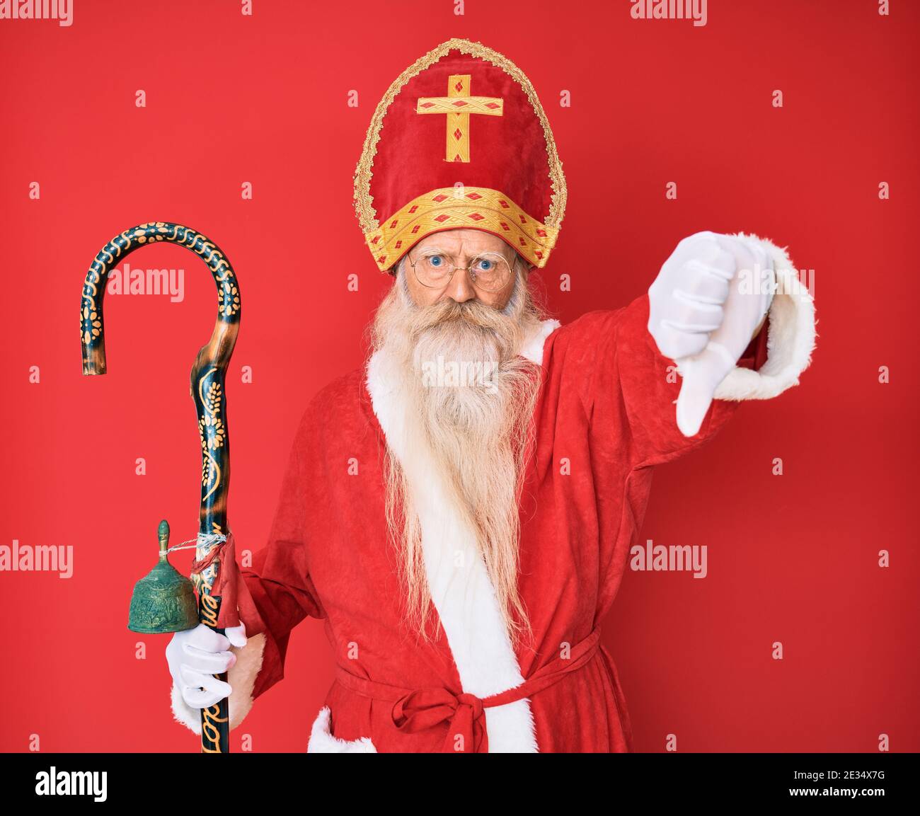 Old senior man with grey hair and long beard wearing traditional saint ...
