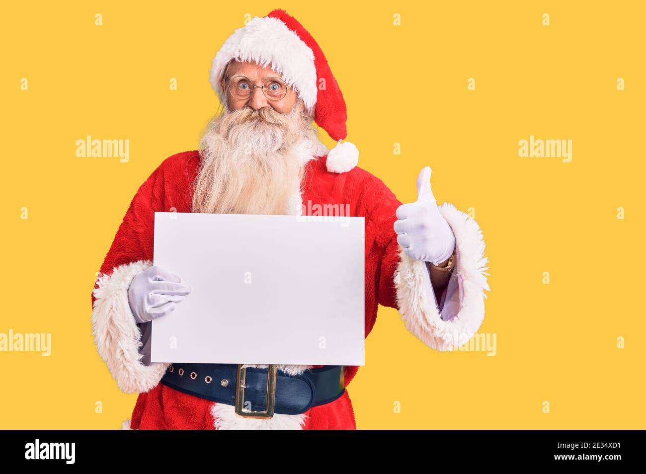 Old senior man with grey hair and long beard wearing santa claus ...