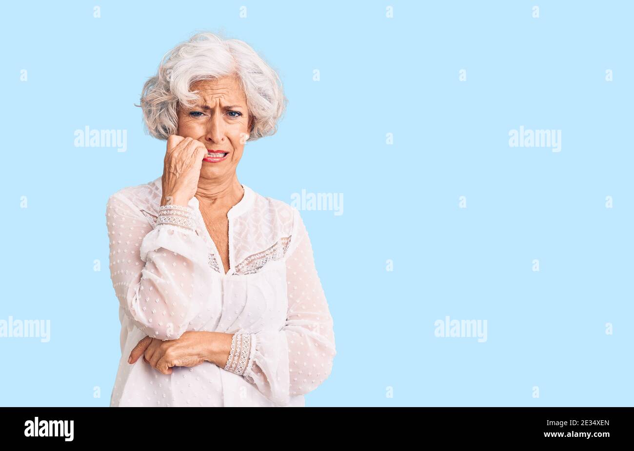 Senior grey-haired woman wearing casual clothes looking stressed and ...