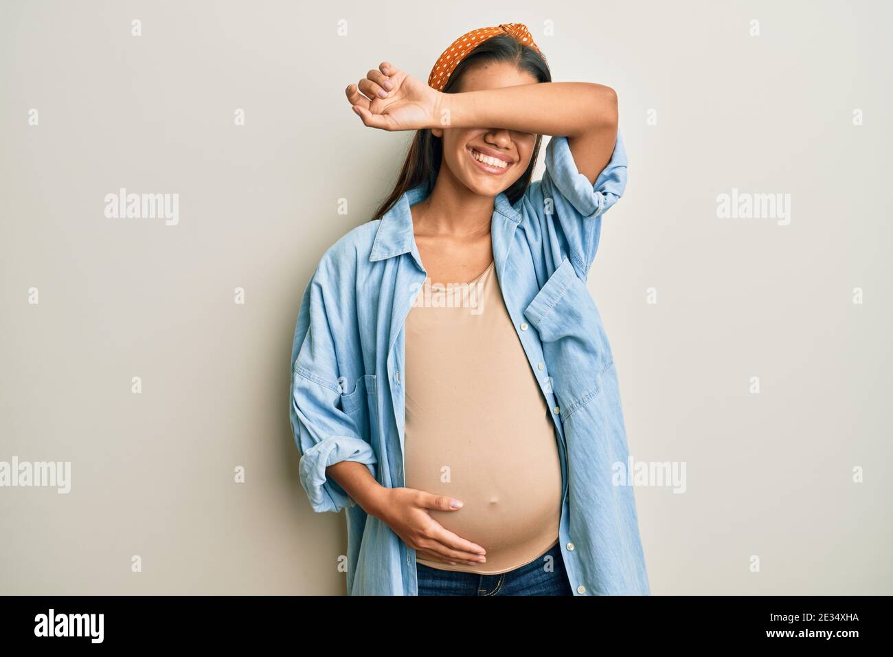 Beautiful hispanic woman expecting a baby, touching pregnant belly ...