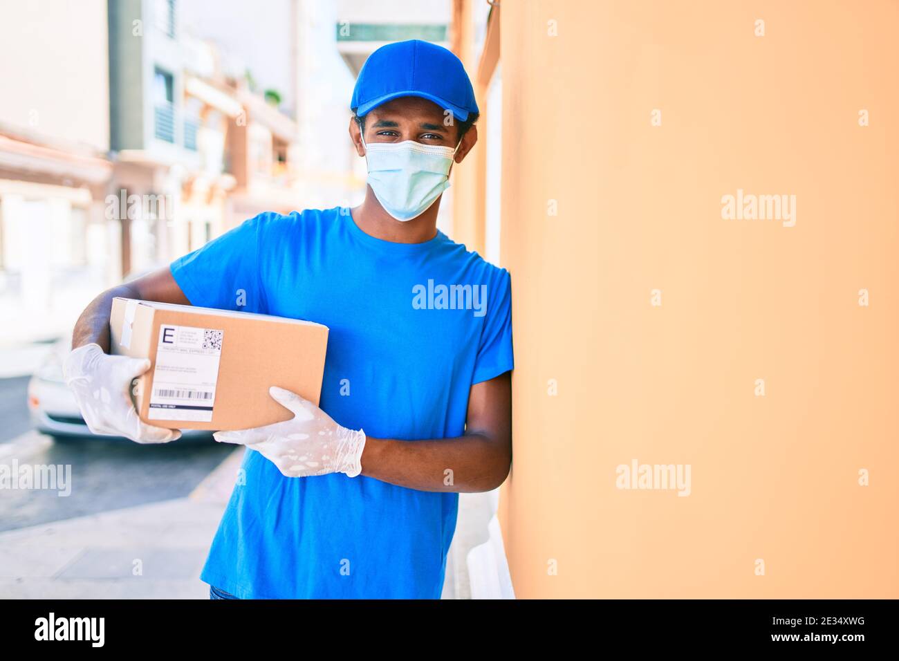 African delivery man wearing courier uniform outdoors wearing ...
