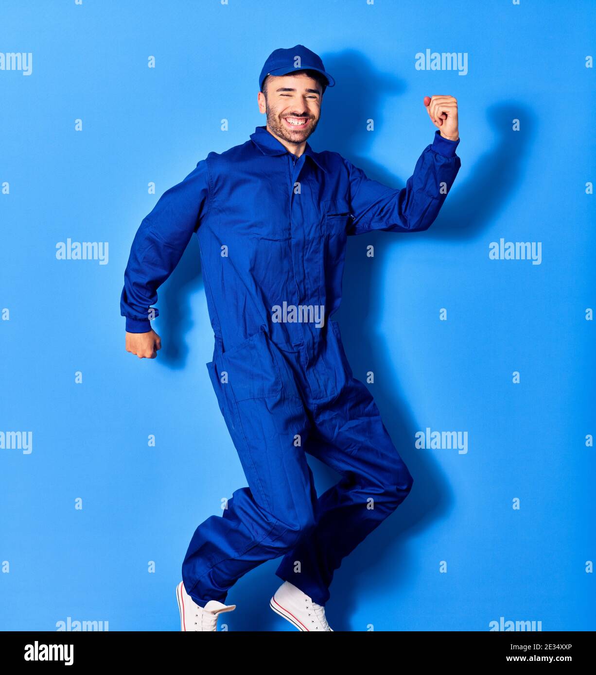 Young handsome hispanic man wearing painter uniform and cap smiling ...