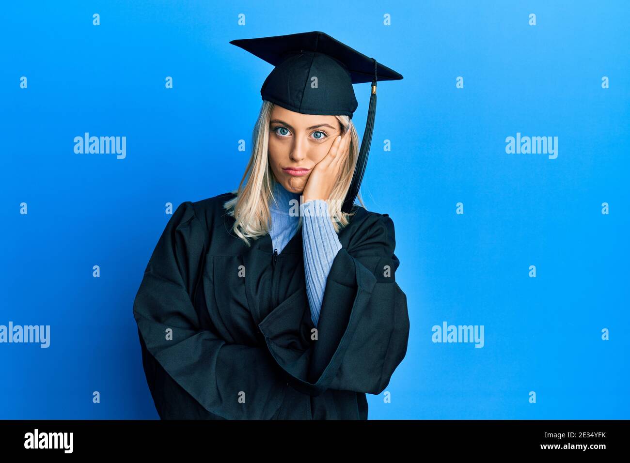 Beautiful blonde woman wearing graduation cap and ceremony robe ...