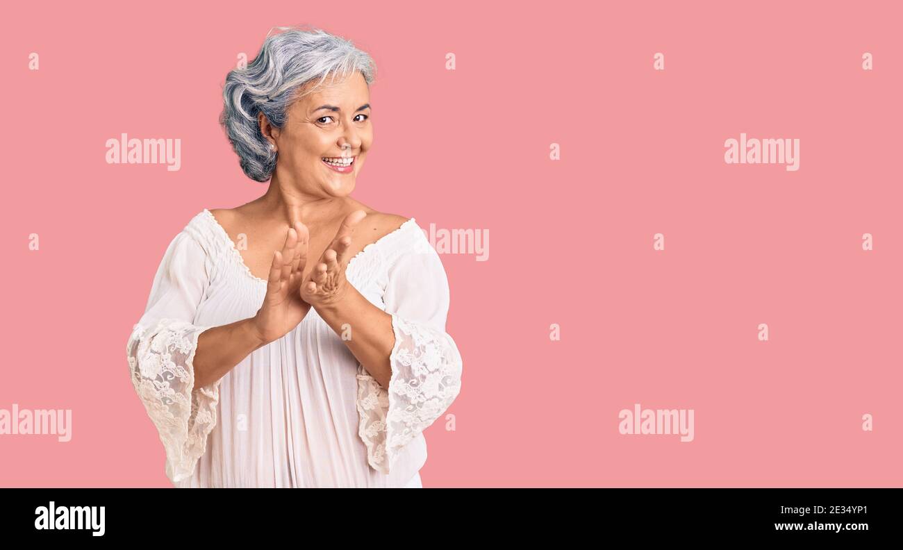 Senior woman with gray hair wearing bohemian style clapping and ...