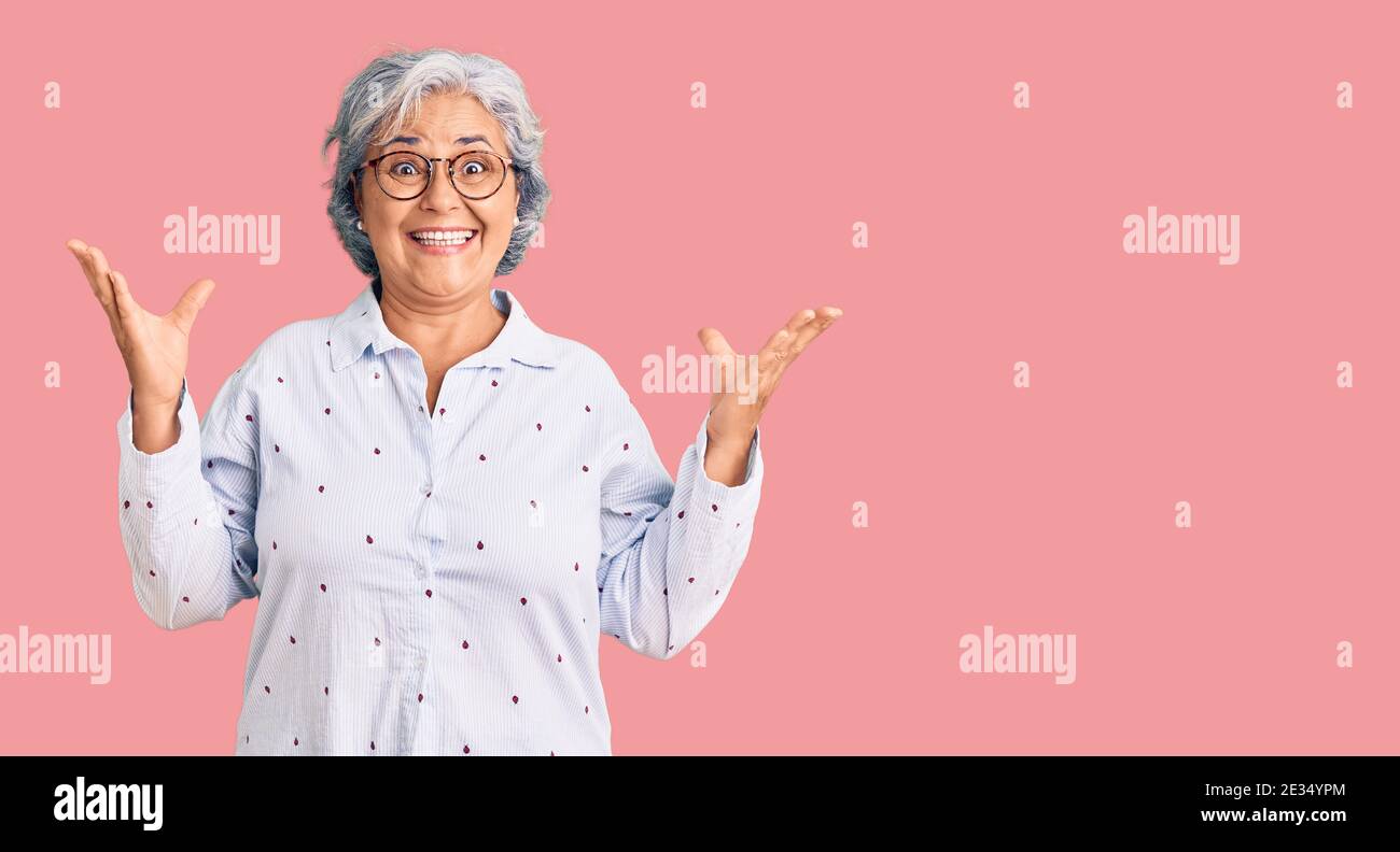 Senior woman with gray hair wearing casual business clothes and glasses ...