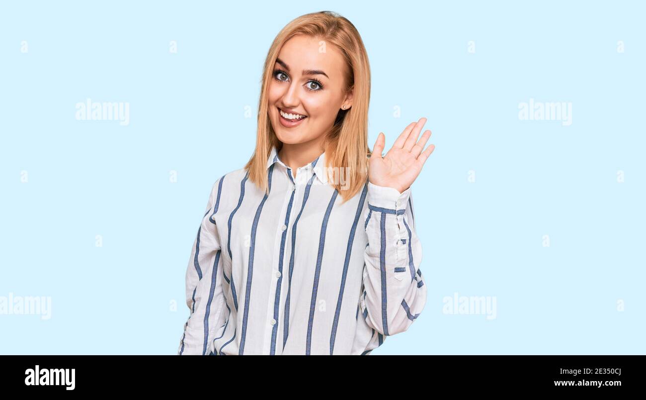 Beautiful caucasian woman wearing casual clothes waiving saying hello ...
