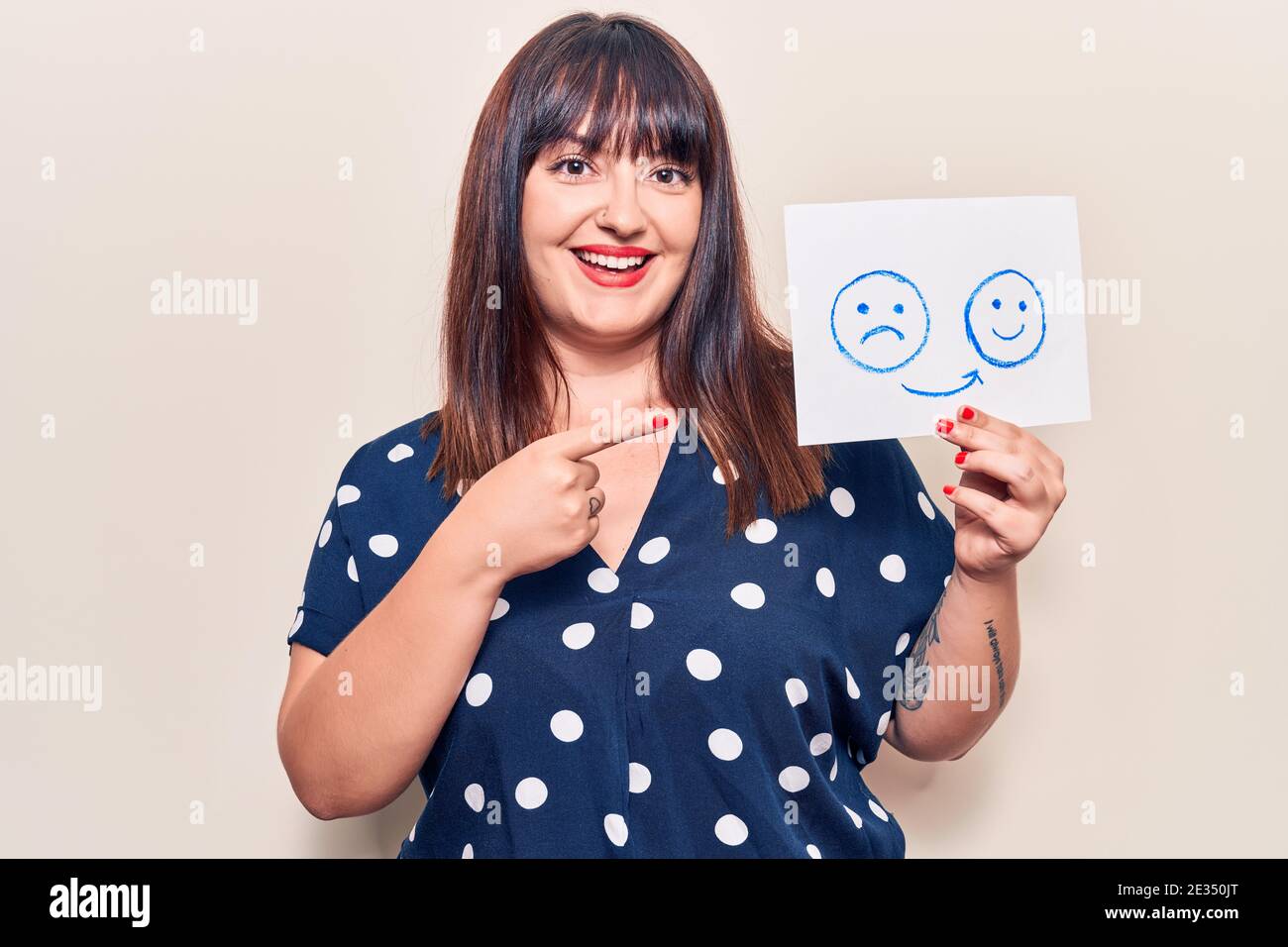 Young plus size woman holding sad to happy emotion paper smiling happy ...