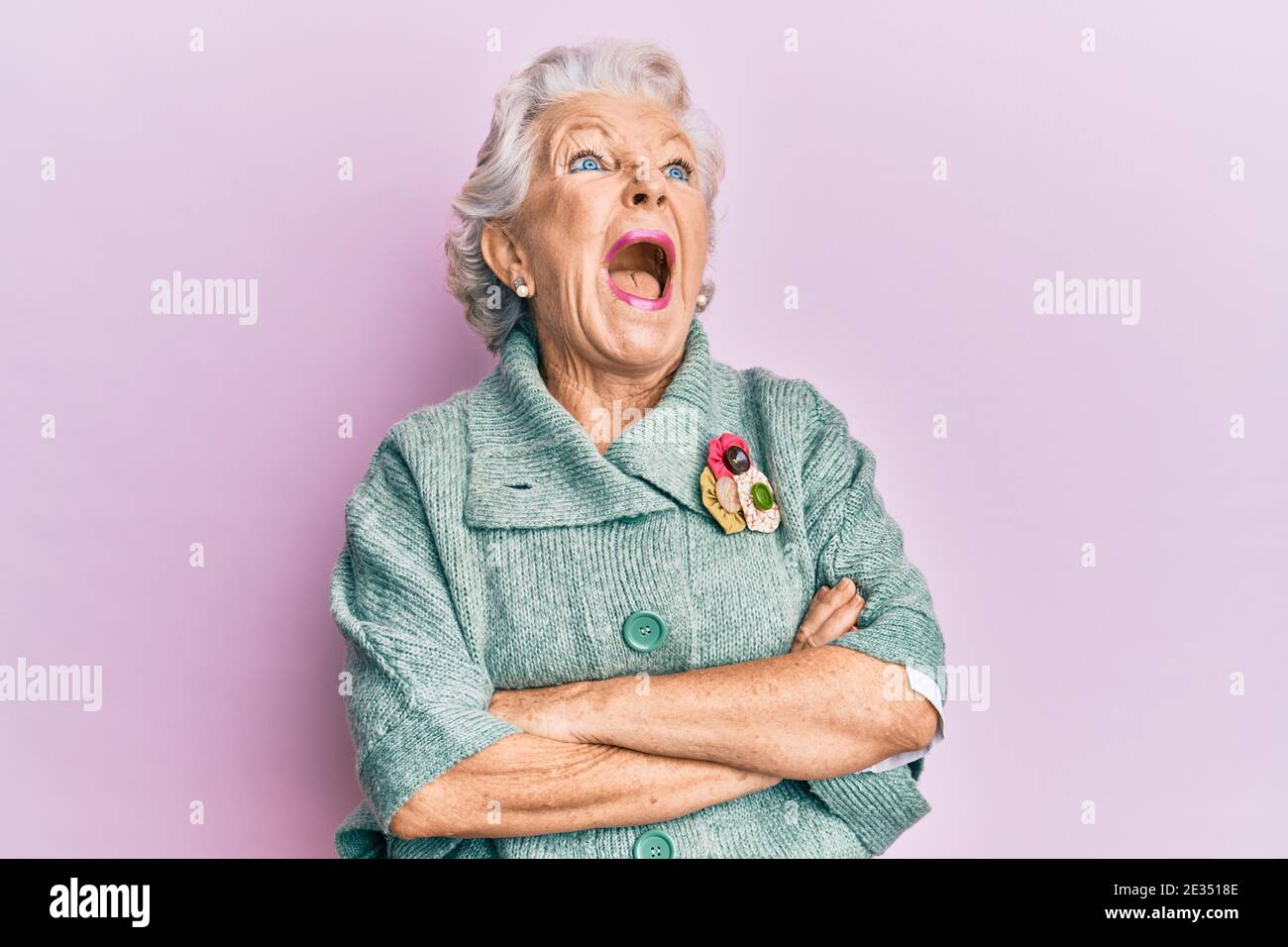 Senior grey-haired woman wearing casual clothes angry and mad screaming ...