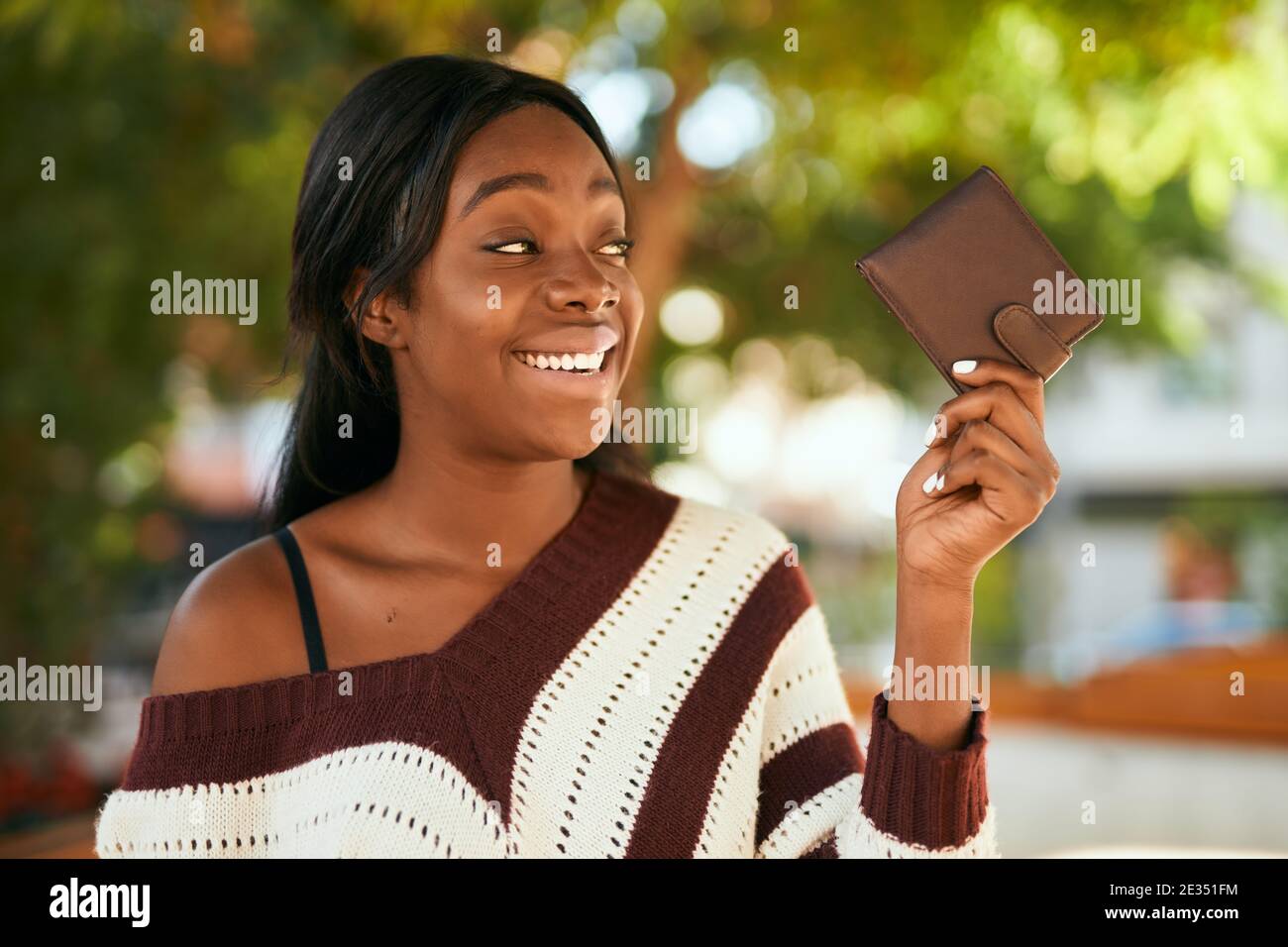 Young african american woman smiling happy holding leather wallet at ...