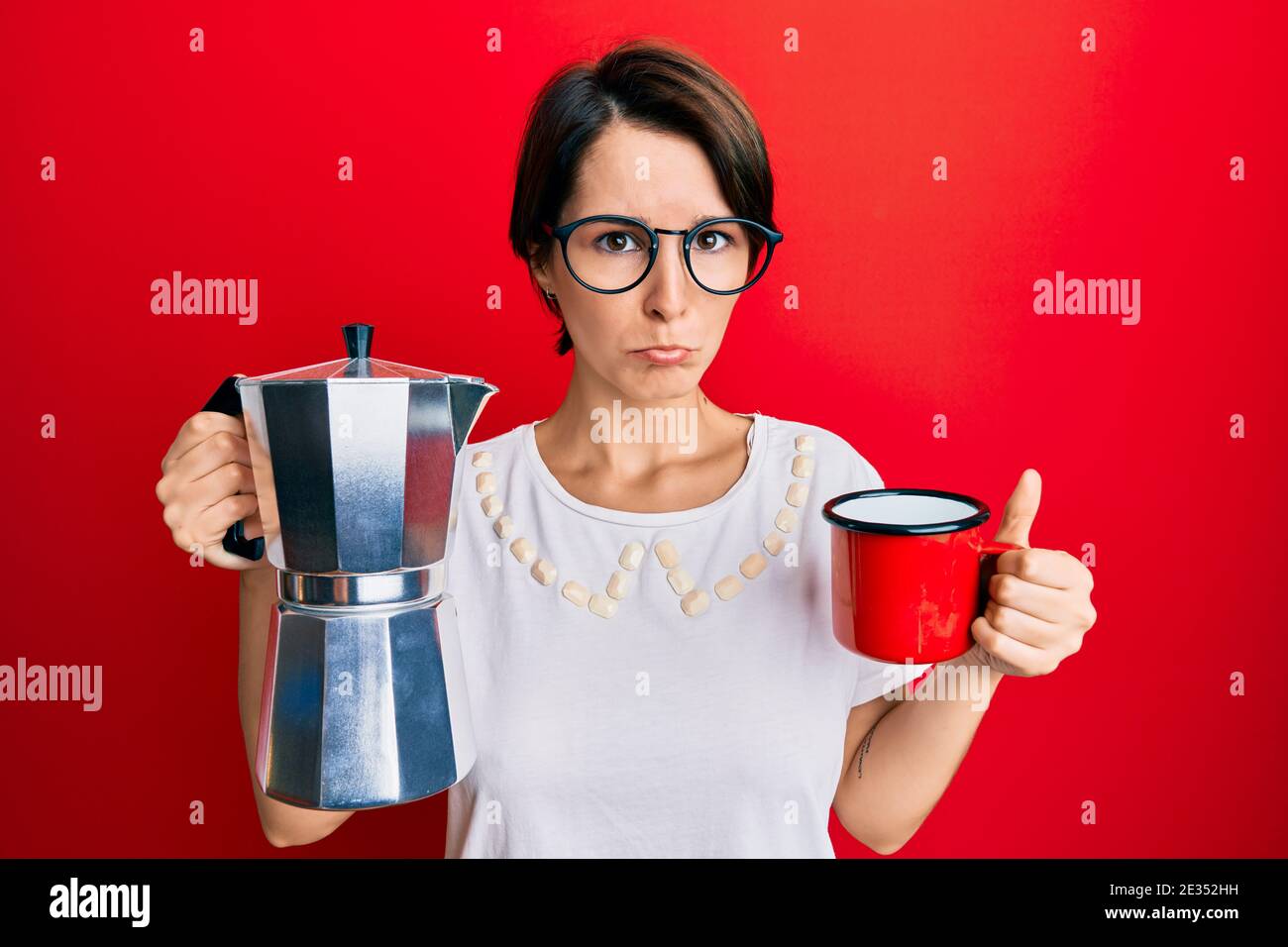 Young brunette woman with short hair drinking italian coffee depressed ...