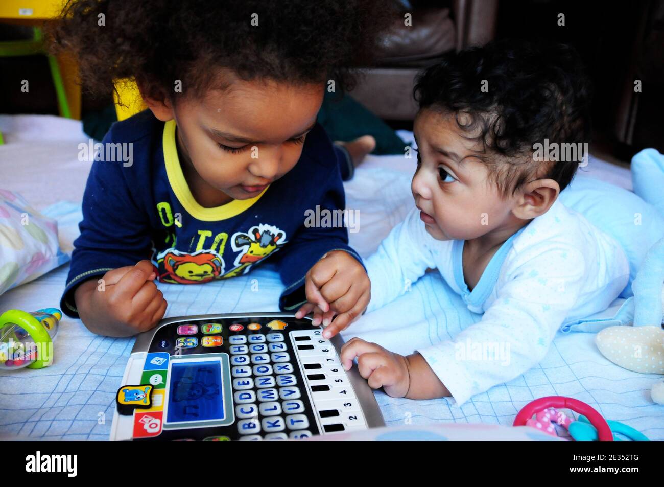 Toddler girl and baby boy playing together on a educational toy Stock ...