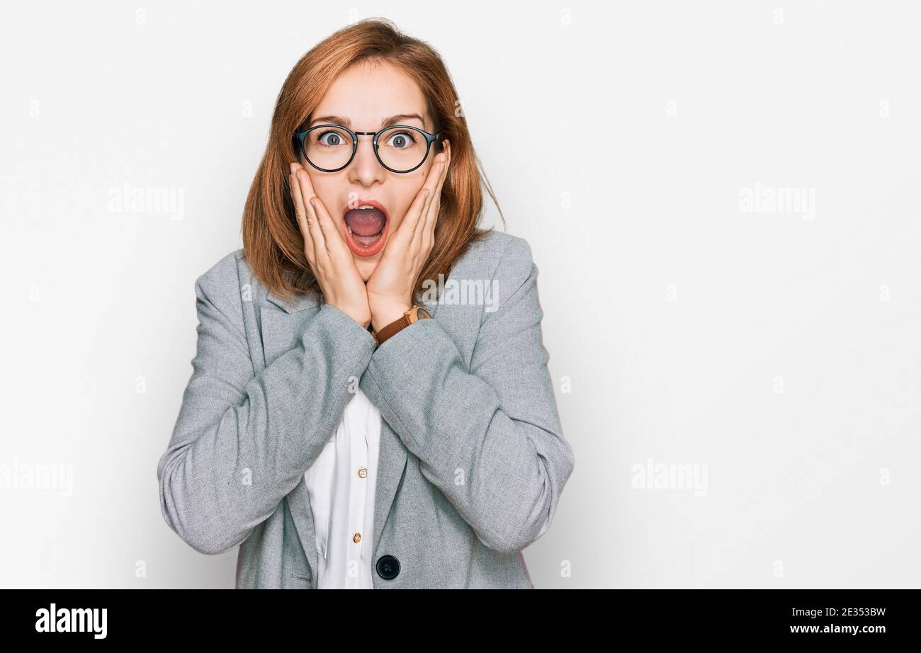 Young caucasian woman wearing business style and glasses afraid and ... Young caucasian woman wearing business style and glasses afraid and ...