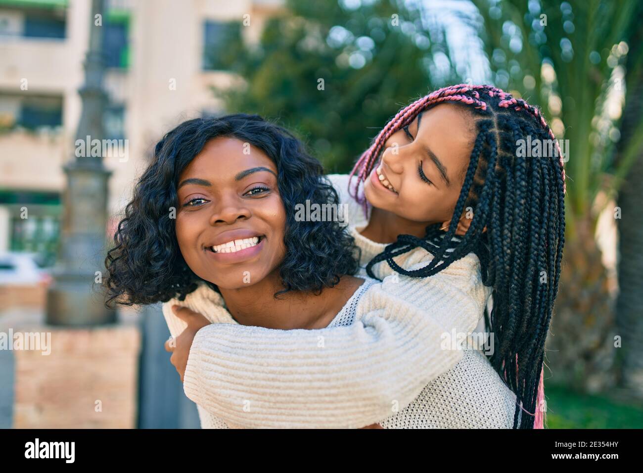 Beautiful african american mother giving daughter piggyback ride ...