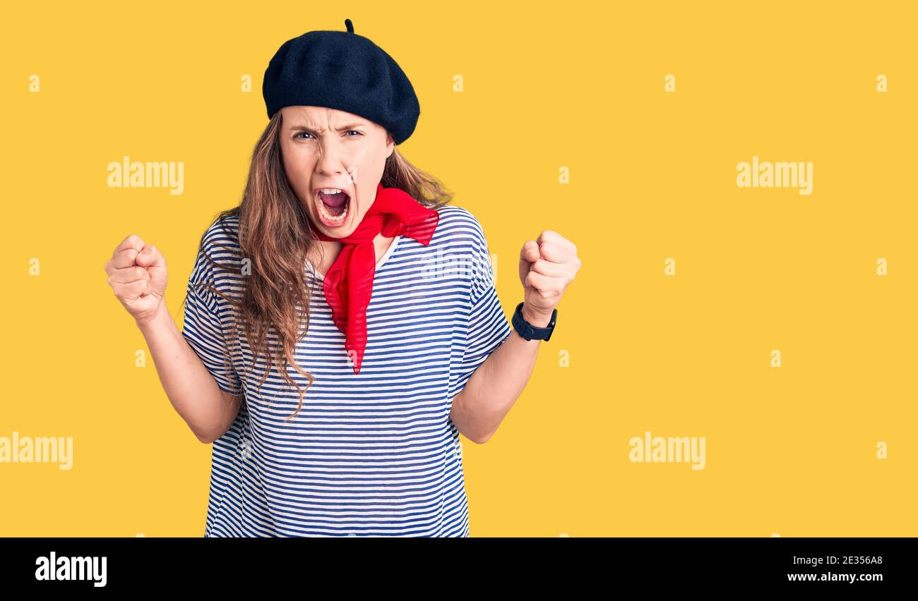 Young beautiful blonde woman wearing french beret and striped t-shirt ...