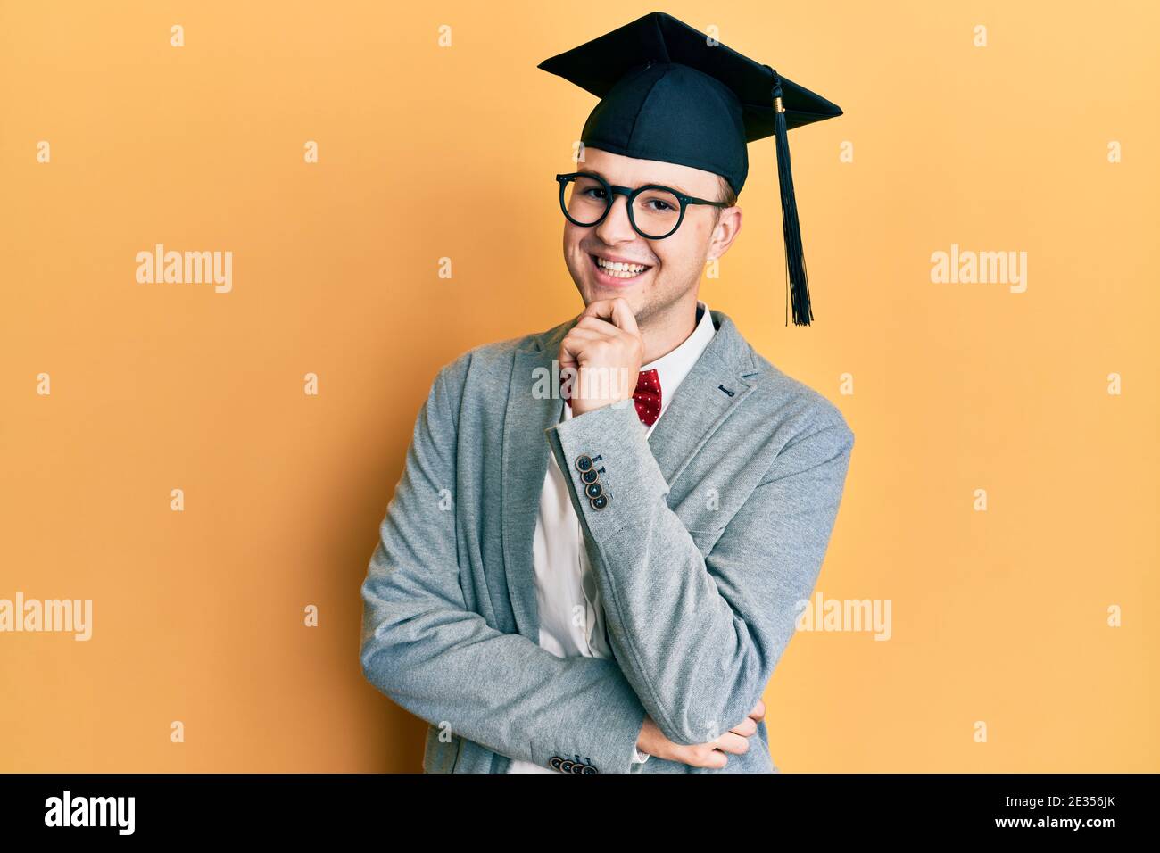 Young caucasian nerd man wearing glasses and graduation cap smiling ...