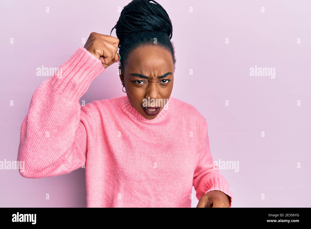 Young african american woman wearing casual winter sweater angry and ...