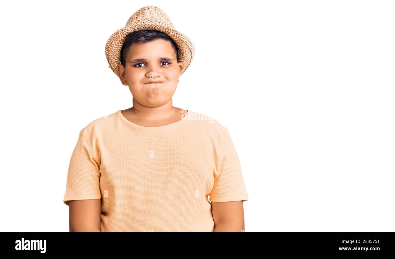 Little boy kid wearing summer hat and hawaiian swimsuit puffing cheeks ...
