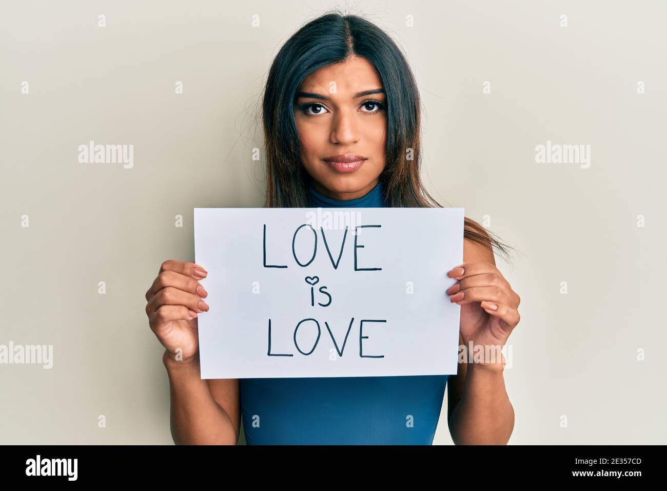 Young latin transsexual transgender woman holding paper with love is ...