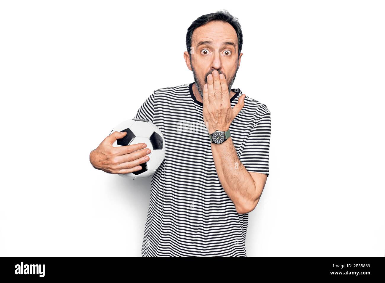 Middle age handsome player man playing soccer holding football ball ...