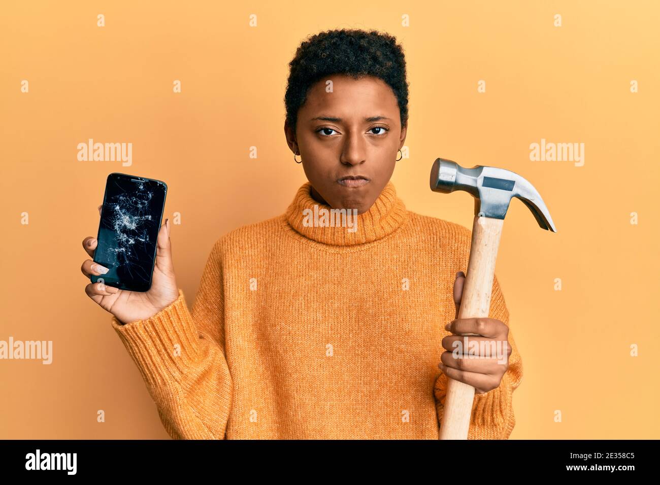 Young african american girl holding broken smartphone showing cracked ...