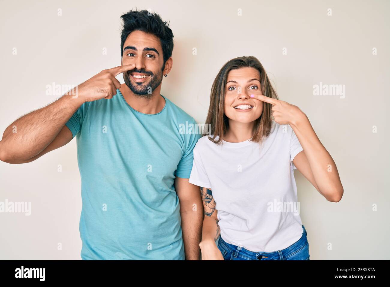 Beautiful young couple of boyfriend and girlfriend together pointing ...