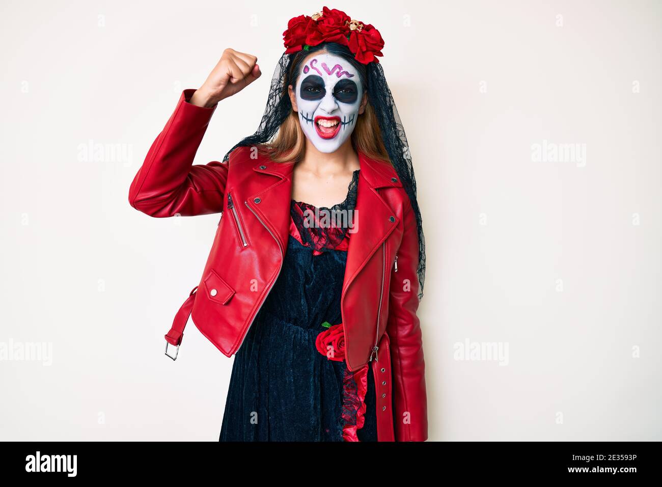 Woman wearing day of the dead costume over white angry and mad raising ...