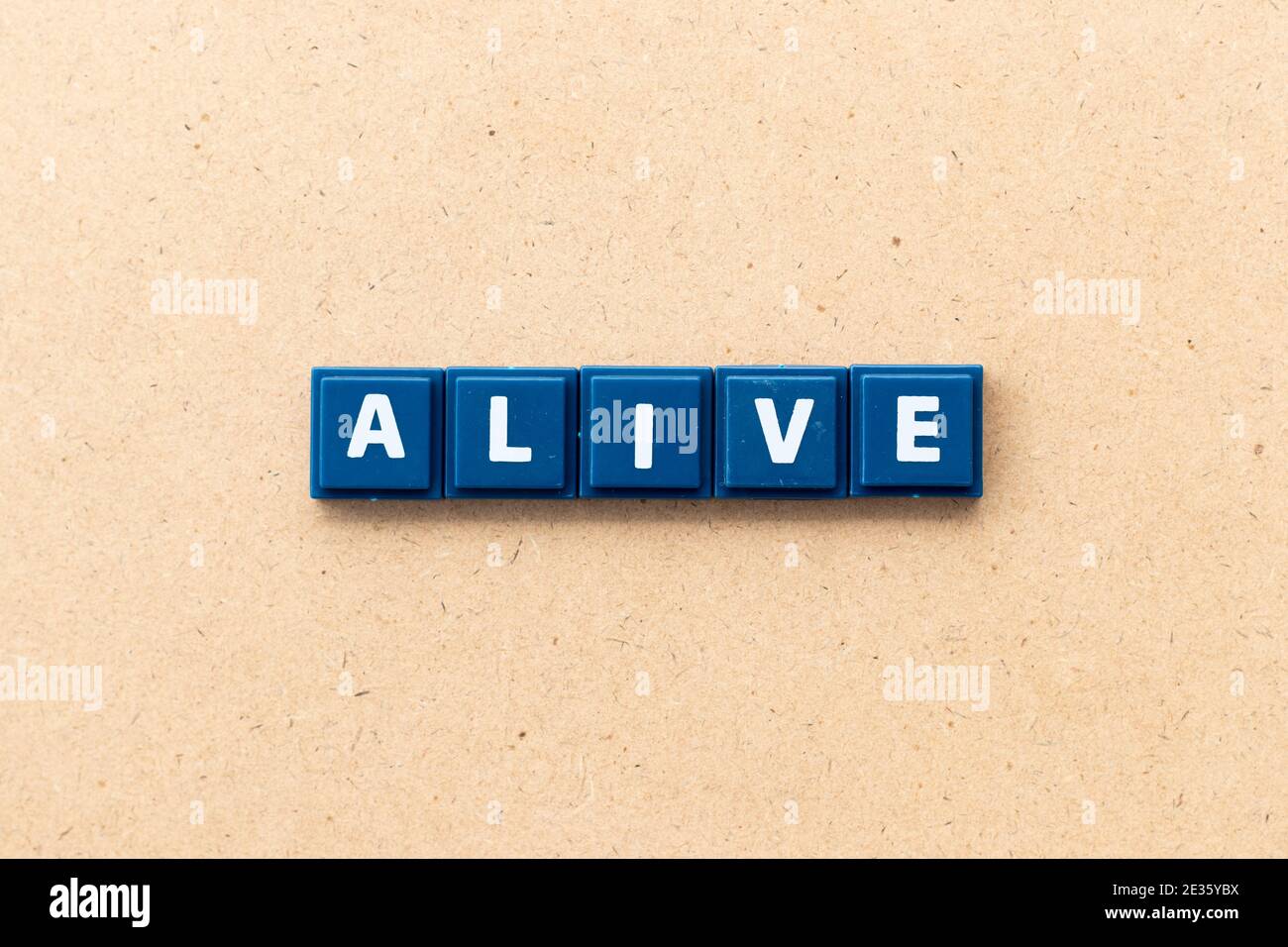 Tile alphabet letter in word alive on wood background Stock Photo - Alamy