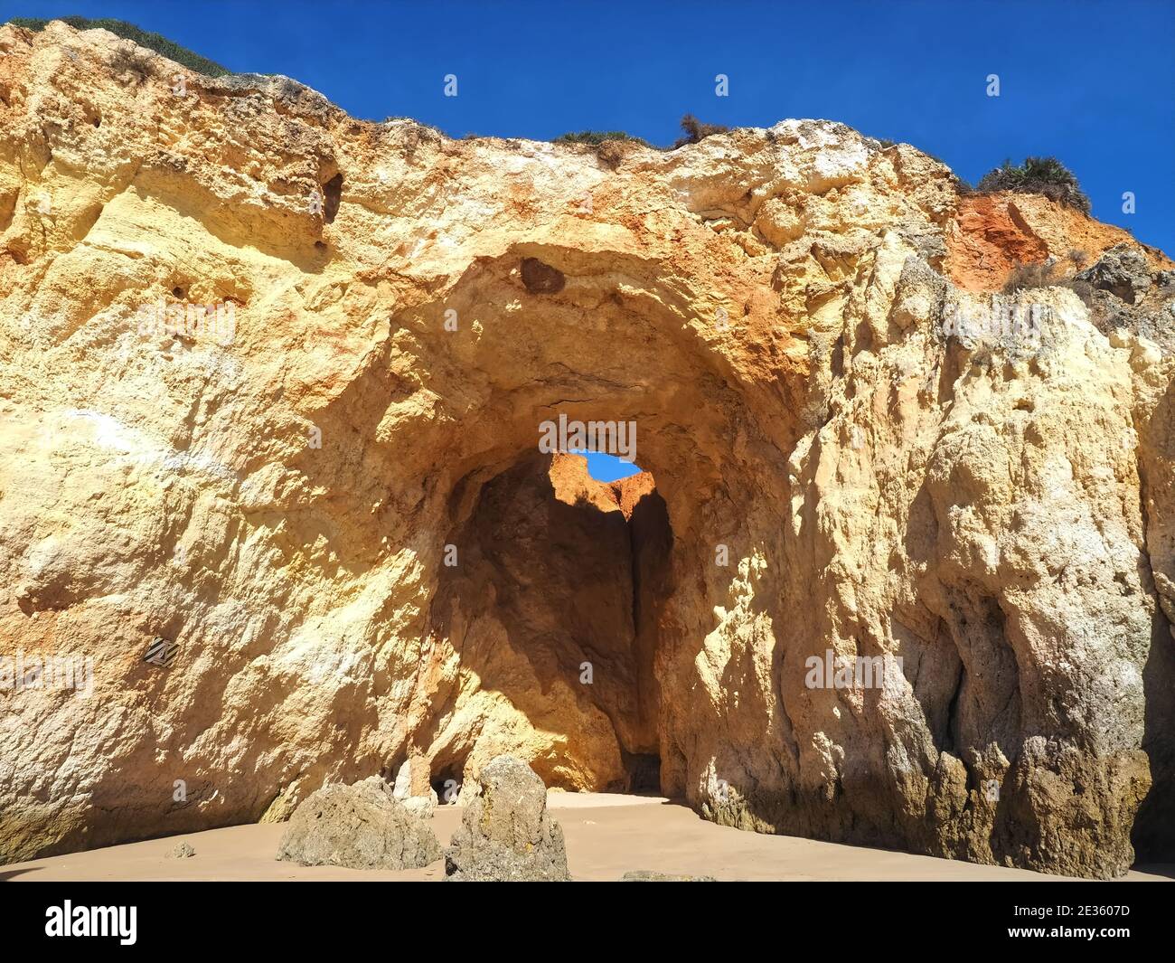 Praia da Vau with a cave with a hole to the blue sky in Portimao ...