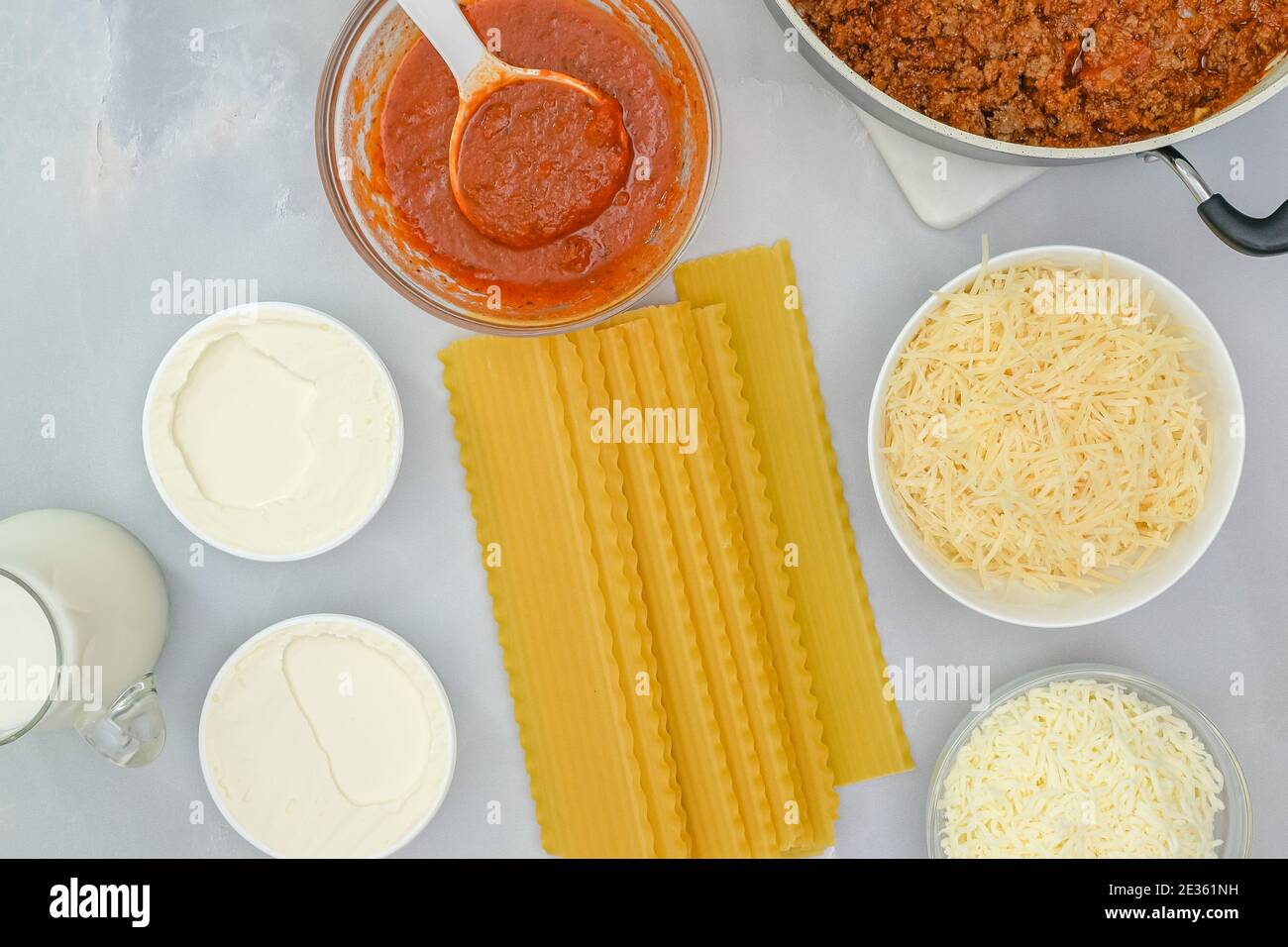 Uncooked lasagna pasta, cheese in the assortment, marinara sauce and ...