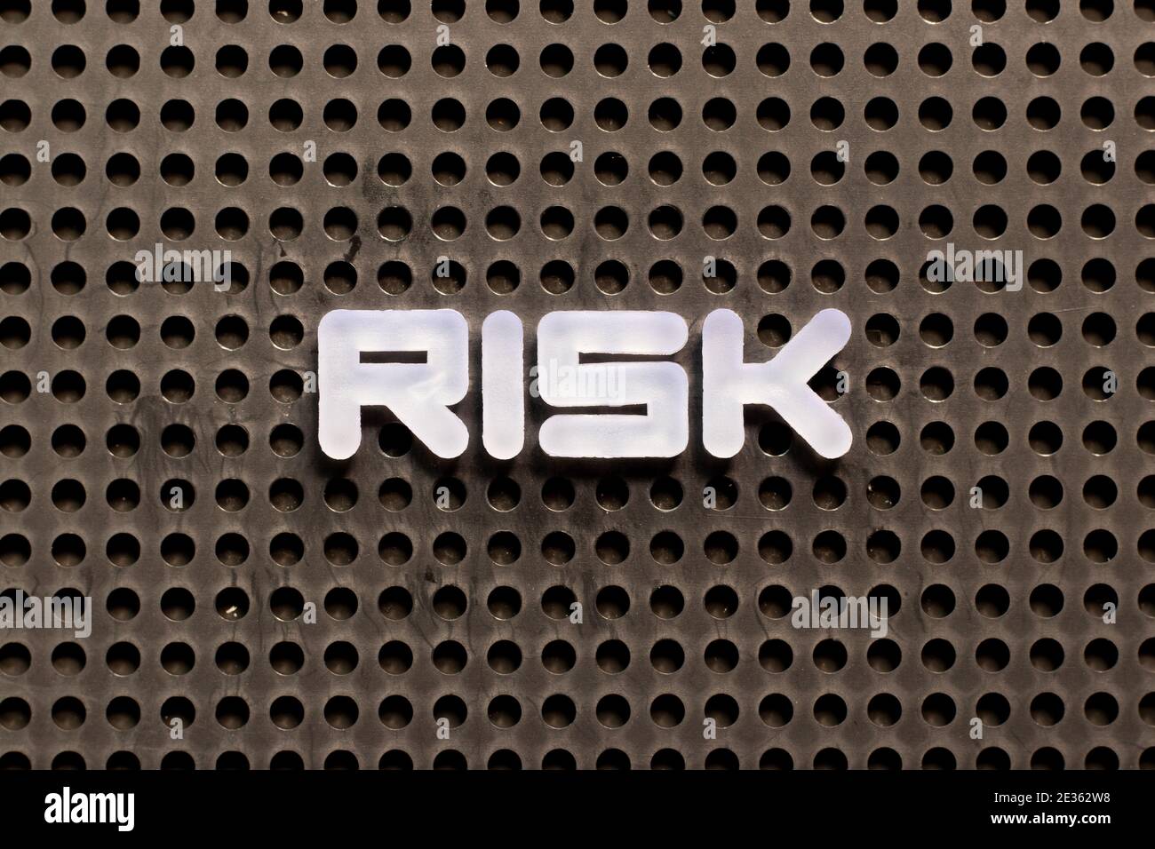 White color letter in word risk on black pegboard background Stock ...
