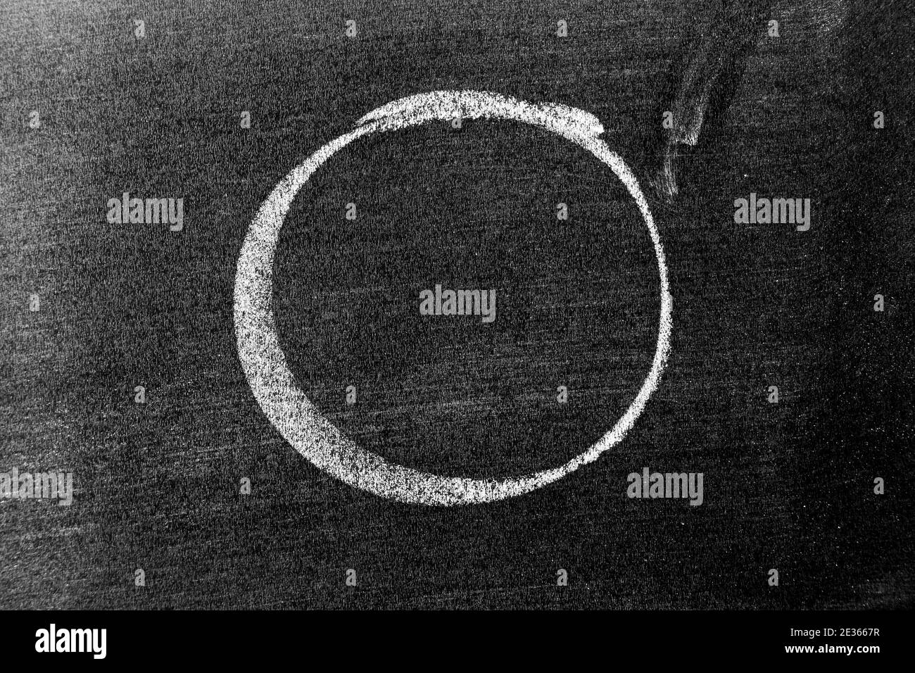 White color chalk hand drawing in circle or oval shape on black board ...