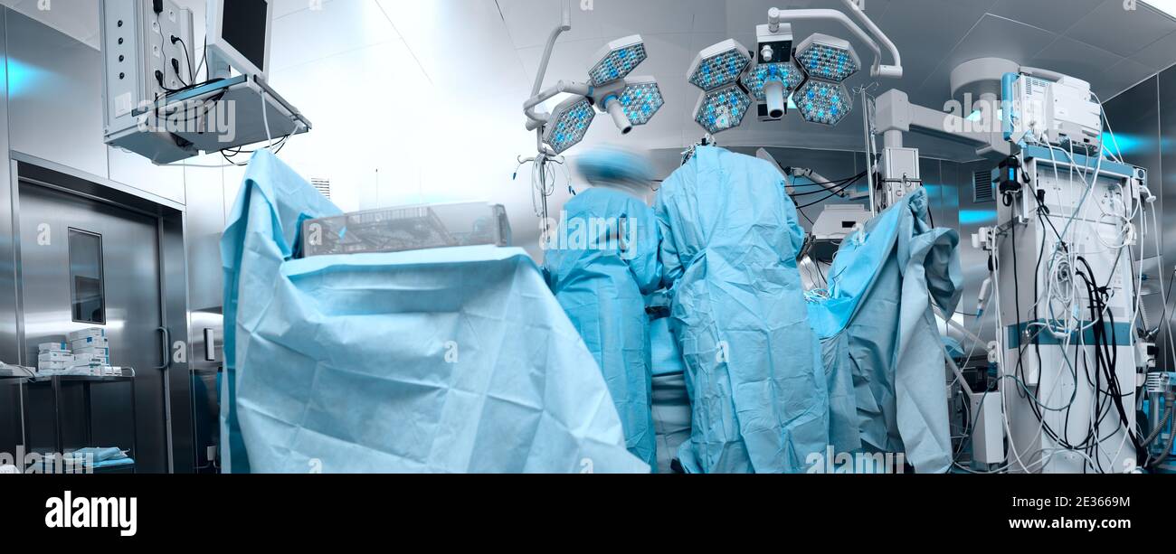 Panoramic image of the modern operating room with the personnel working ...