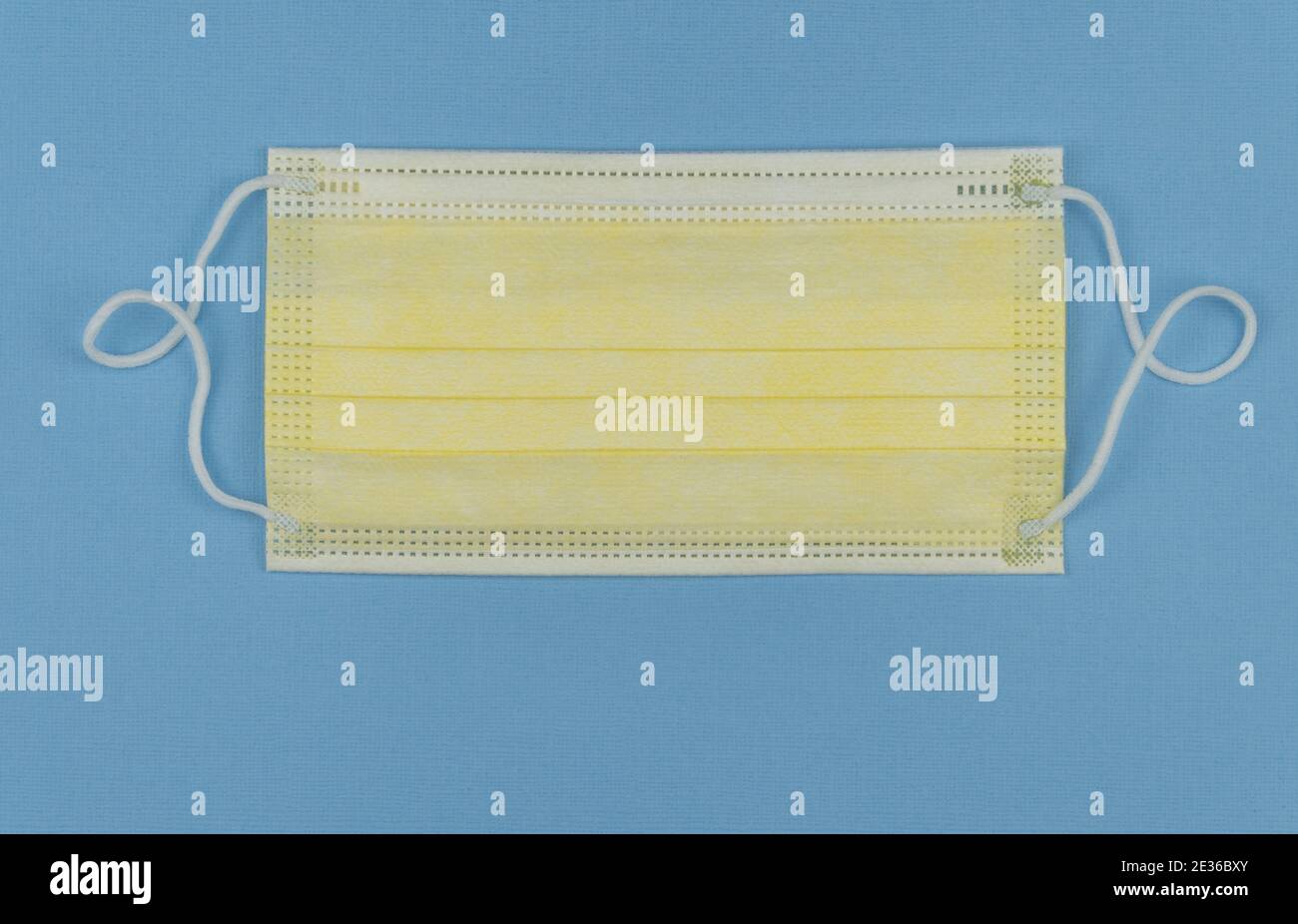 disposable surgical mask of yellow color on a blue background Stock ...