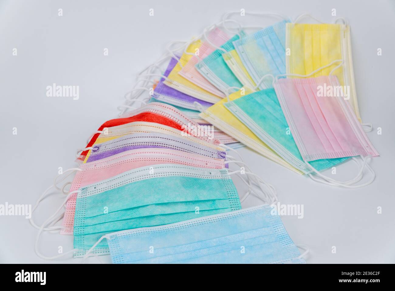disposable medical masks of different colors on a white background ...