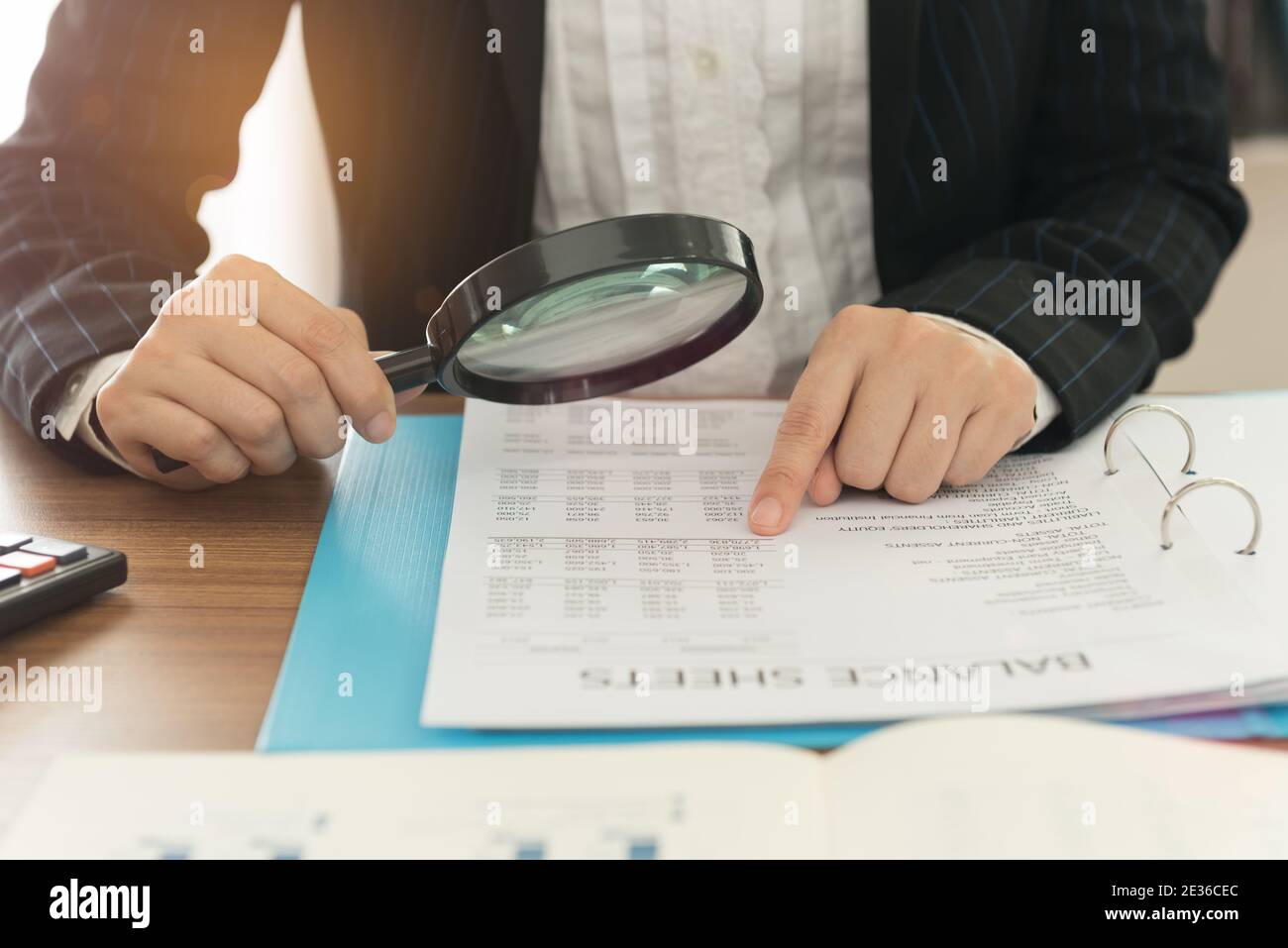 Business women using magnifying to review balance sheet annual. Concept ...