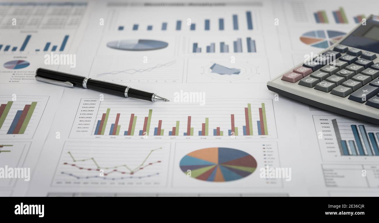 financial graph and chart report with pen, calculator on desk of ...