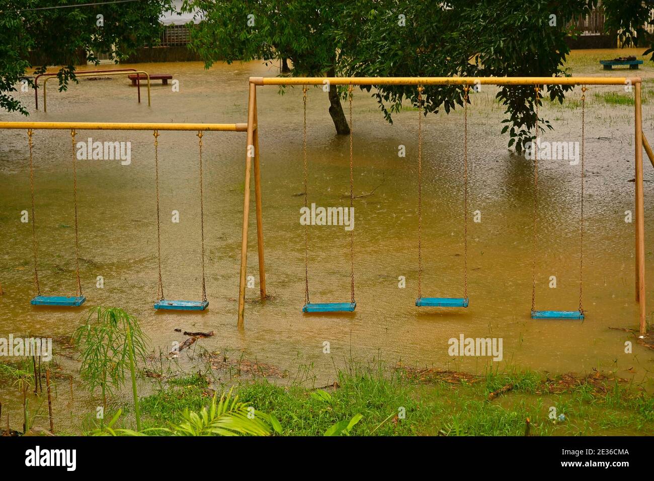 Playground swings with flooded ground and grass underneath Stock Photo ...