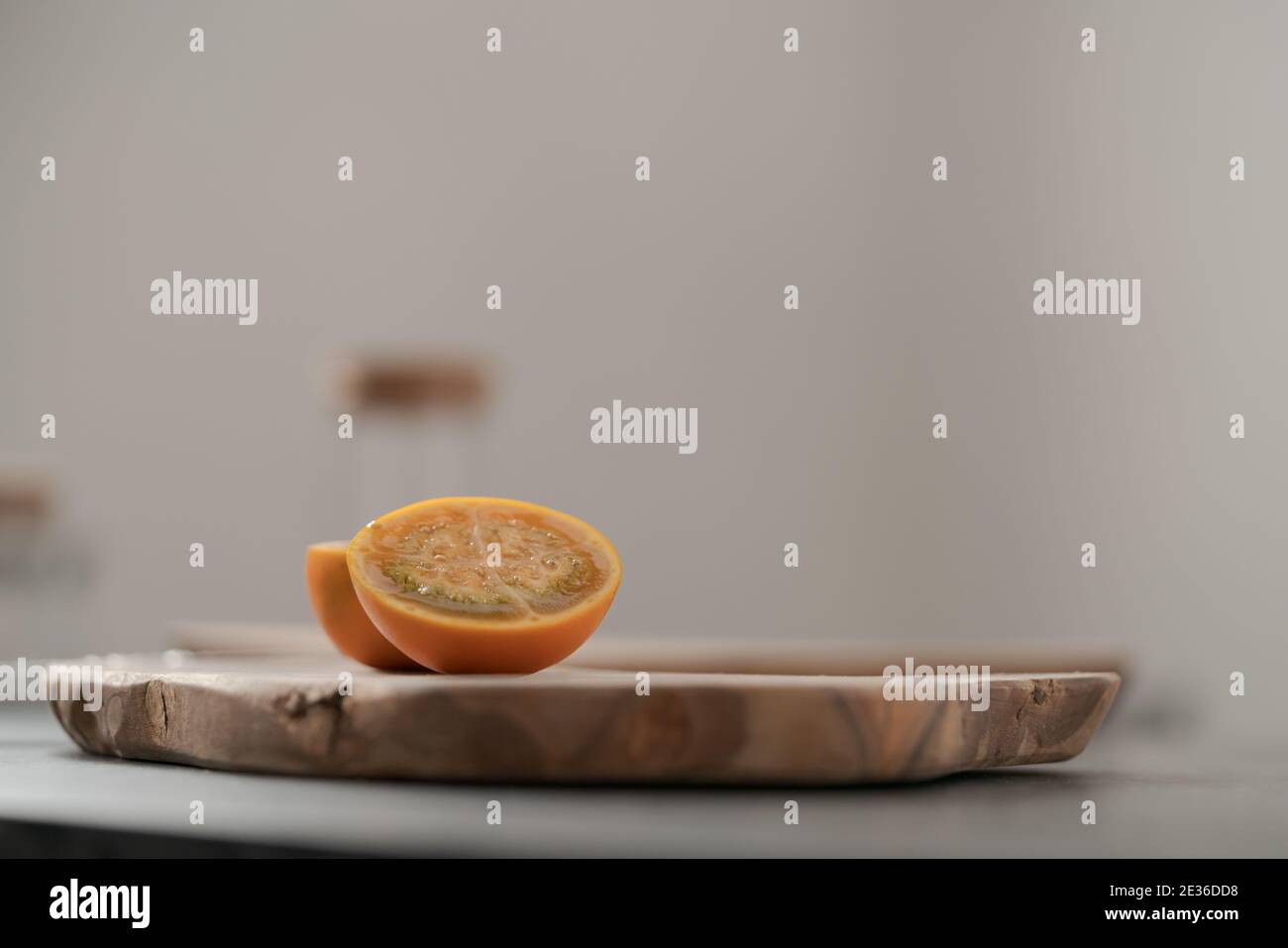 Lulo fruit sliced in halves on olive wood board on kitchen countertop ...
